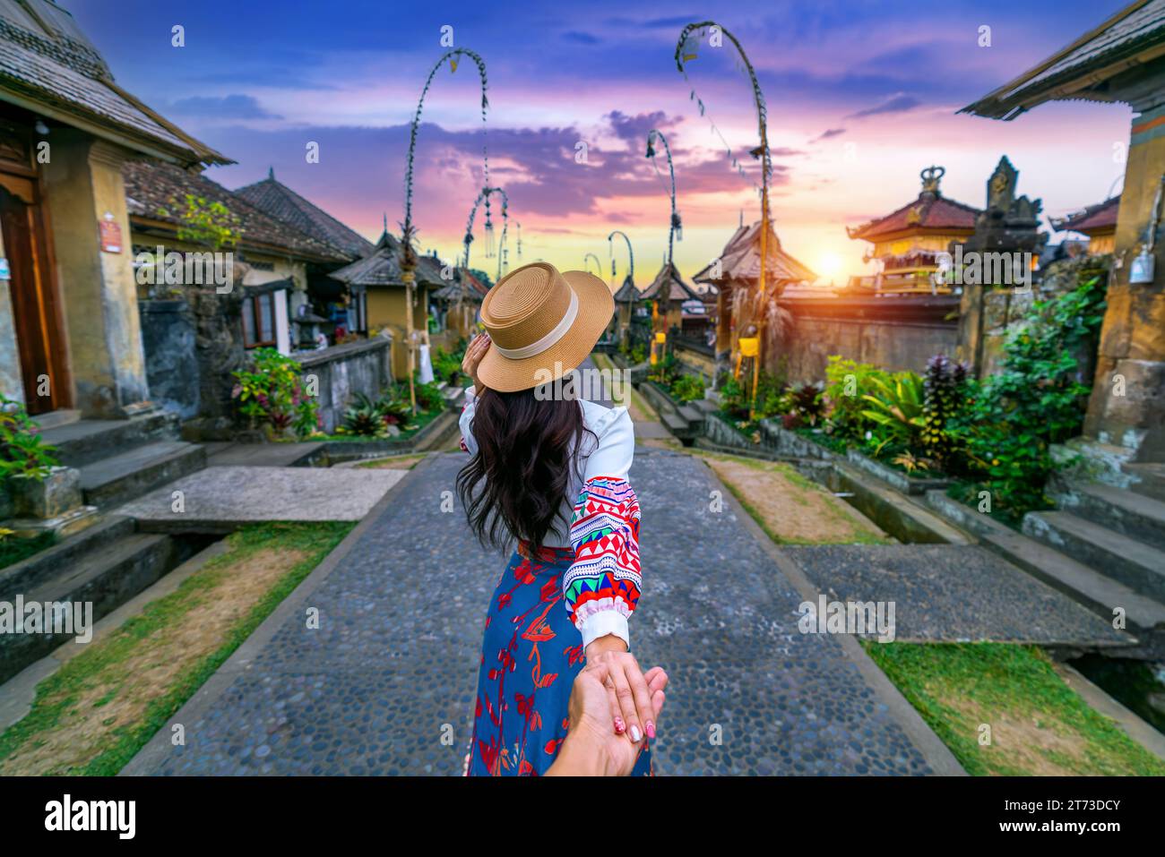 Women tourists holding man's hand and leading him to Penglipuran ...