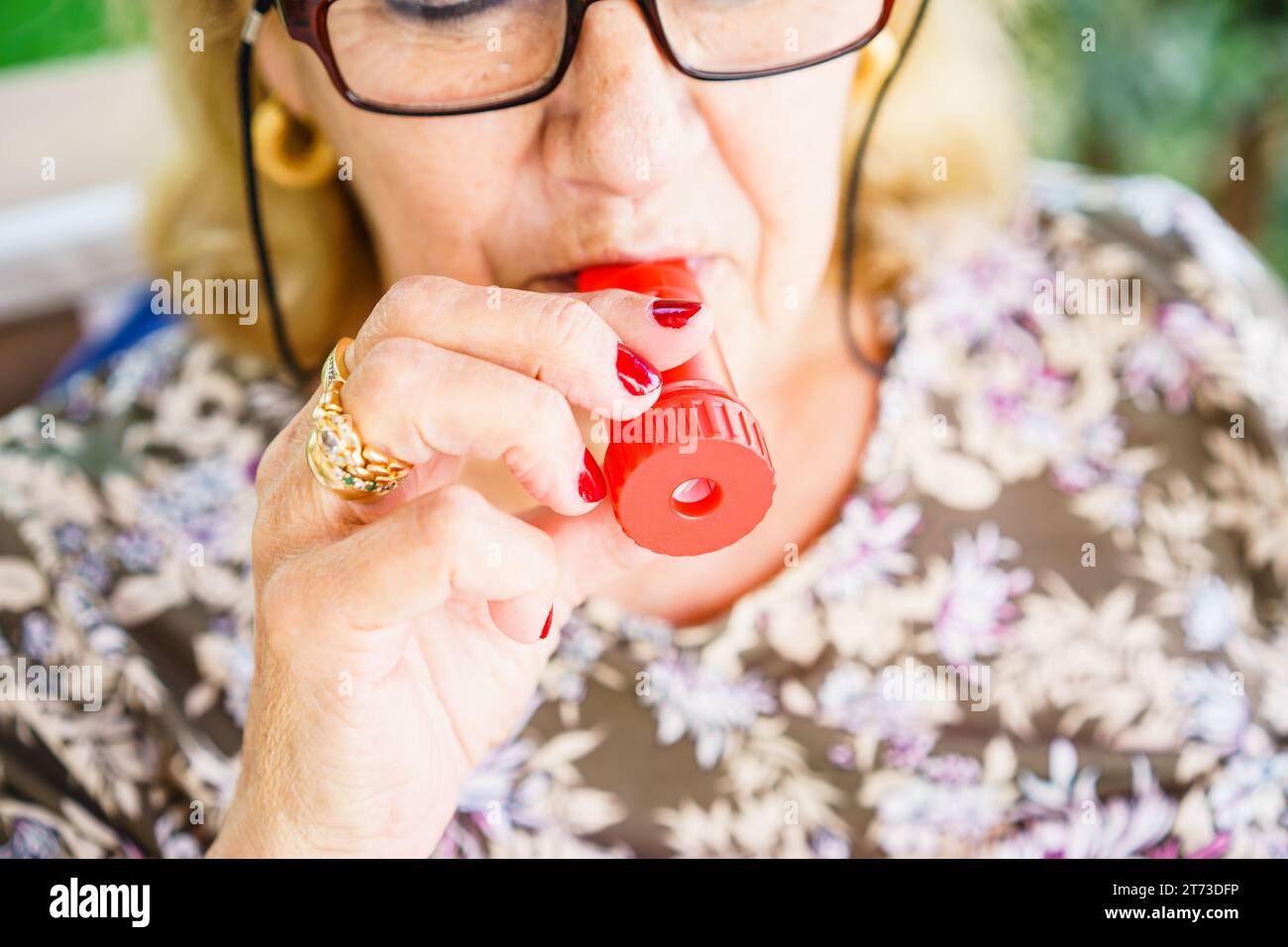 A female individual using an inhaler to help manage her asthma Stock ...