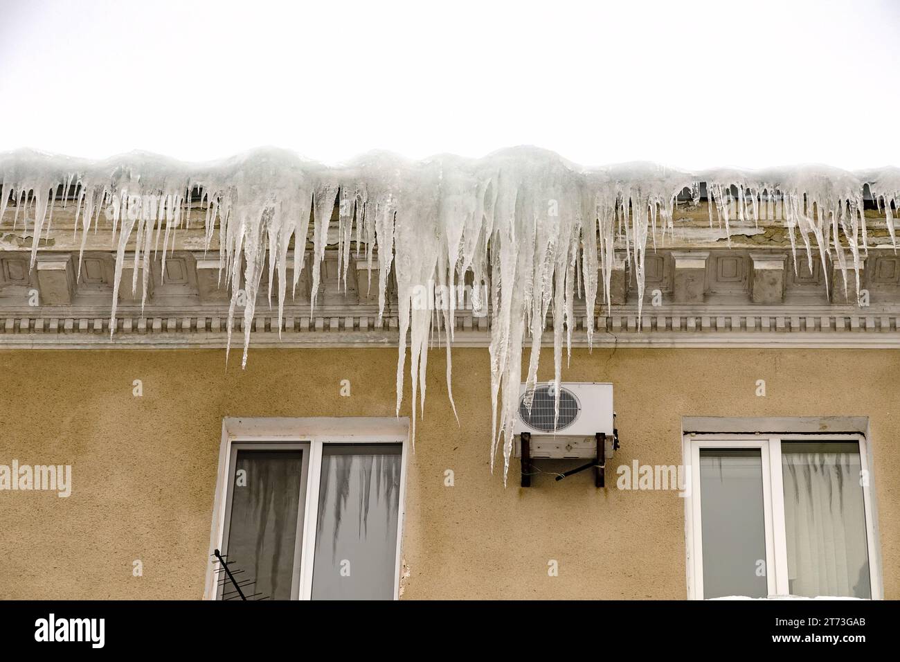 Huge pieces of ice hanging from the eaves of buildings threatening to ...