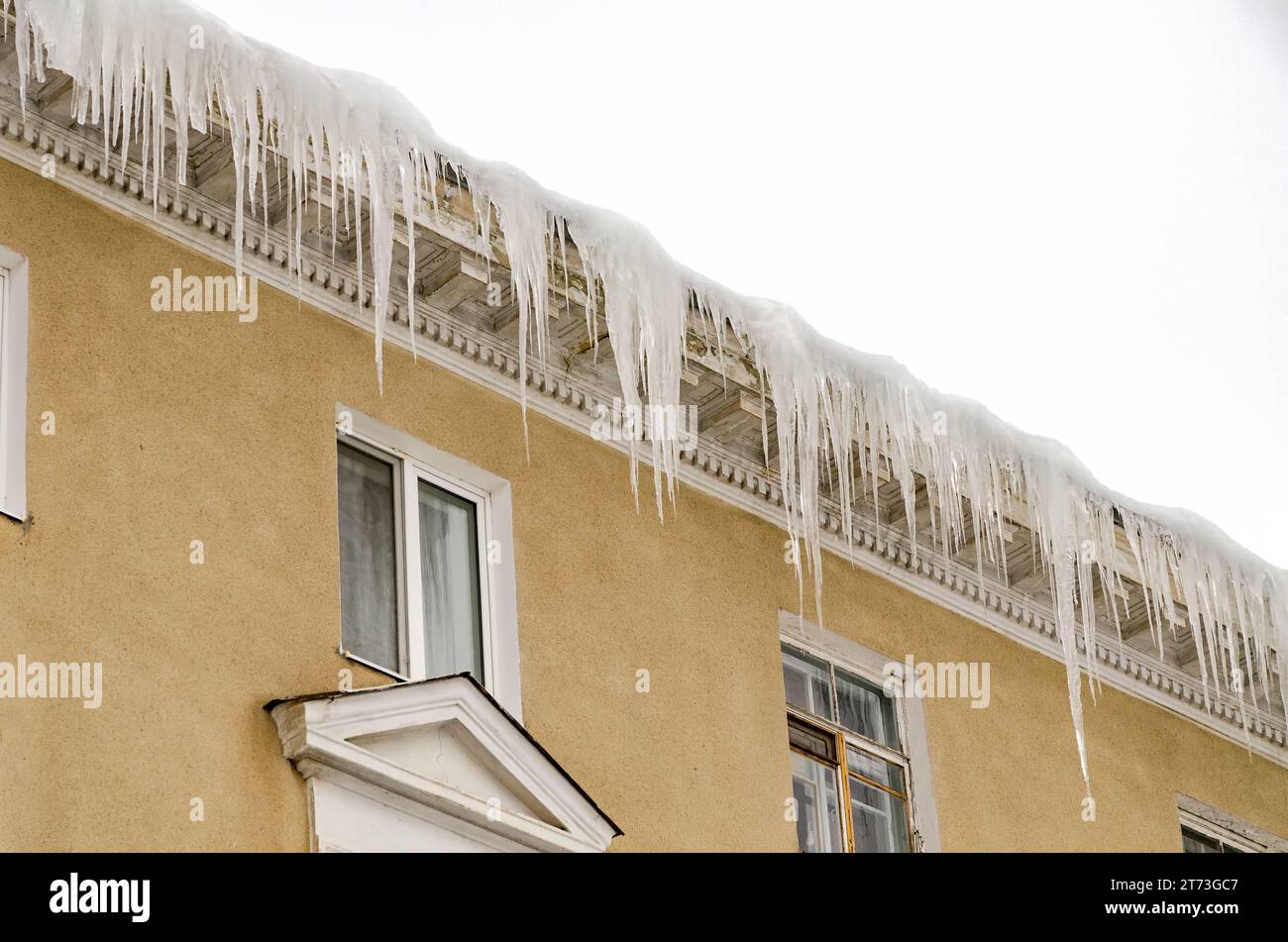 Huge pieces of ice hanging from the eaves of buildings threatening to ...