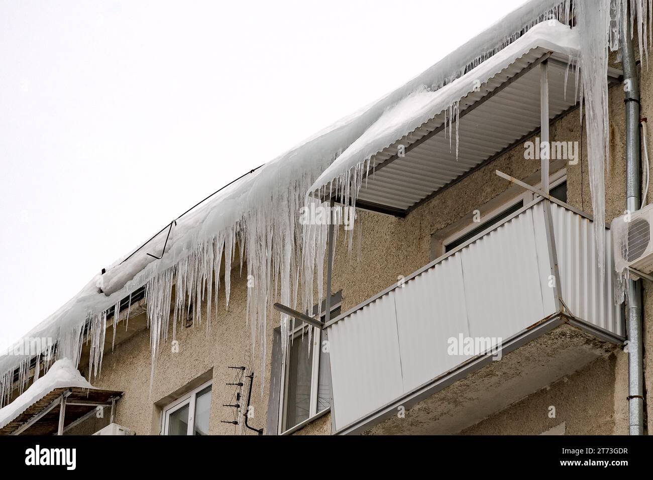 Huge icicles hang from the roof Stock Photo - Alamy