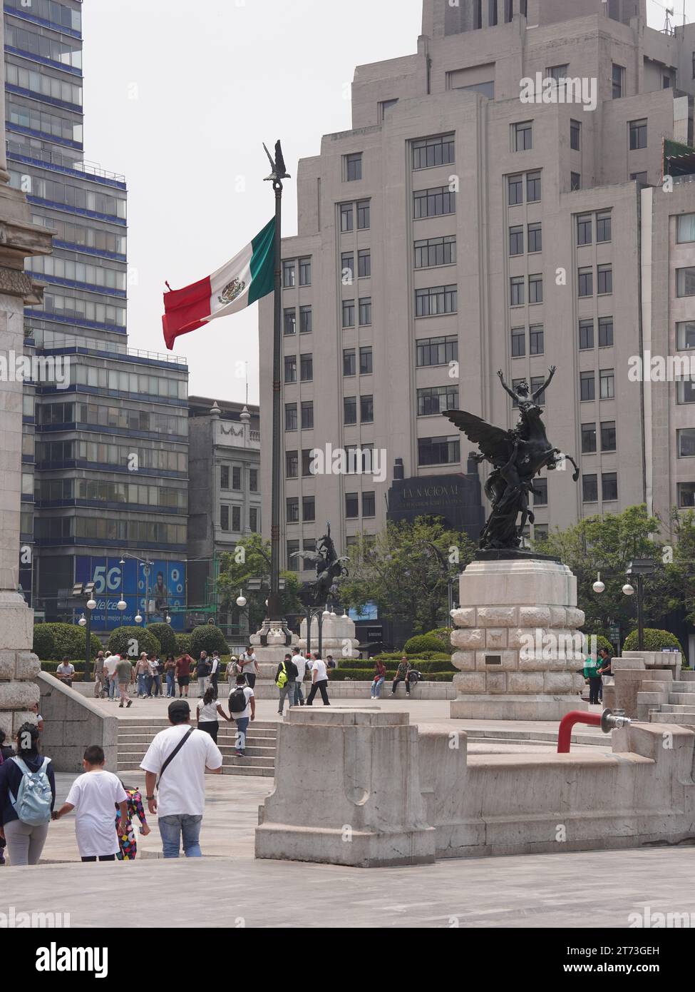 A diverse group of people walking together in a public plaza in Mexico ...