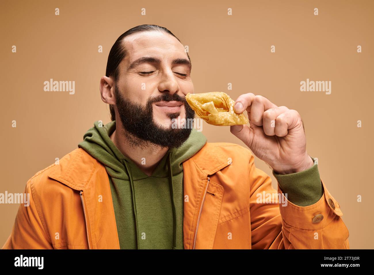 joyful man smelling honey baklava on beige background, traditional ...