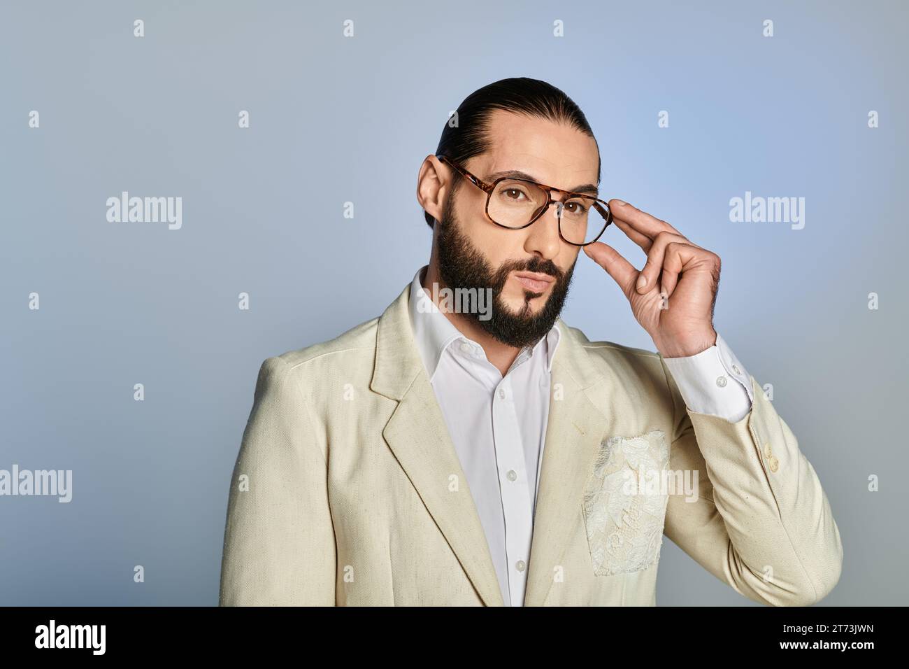 Elegant And Bearded Man In Eyeglasses And White Attire Posing On Grey