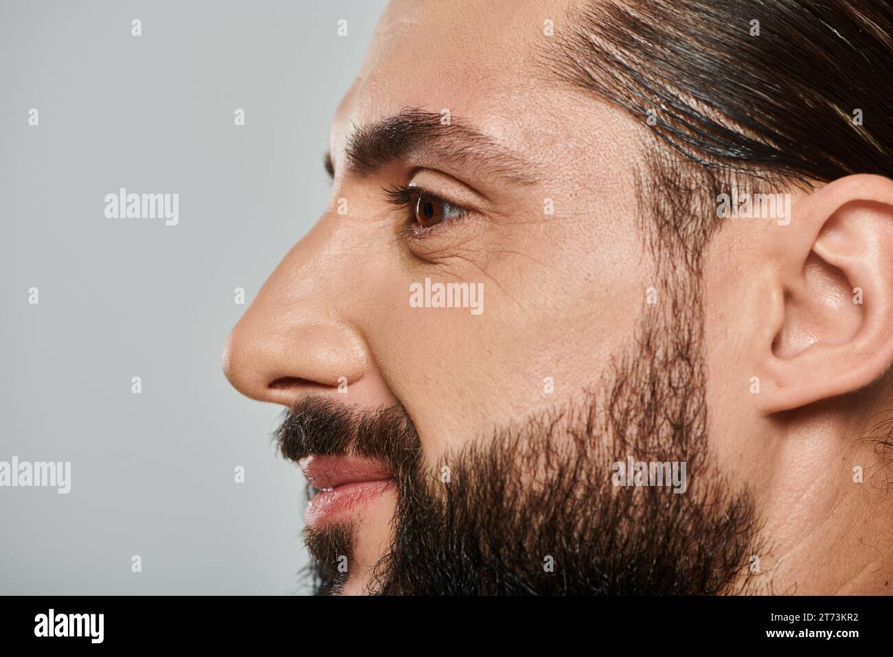 profile of cheerful arabic man with beard smiling and looking away on ...