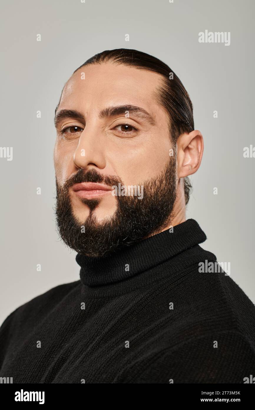 portrait of masculine arabic man with beard posing in black turtleneck ...