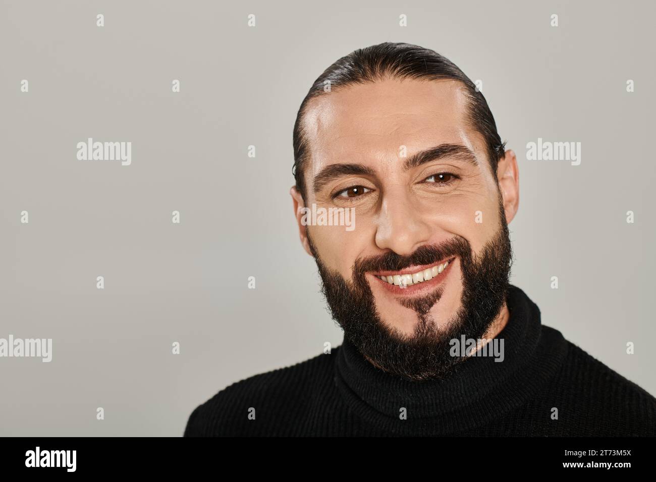 portrait of happy good looking arabic man with beard posing in black ...