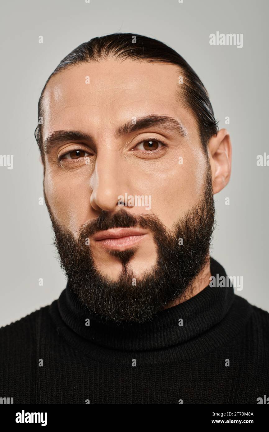 portrait of masculine arabic man with beard posing in black turtleneck ...