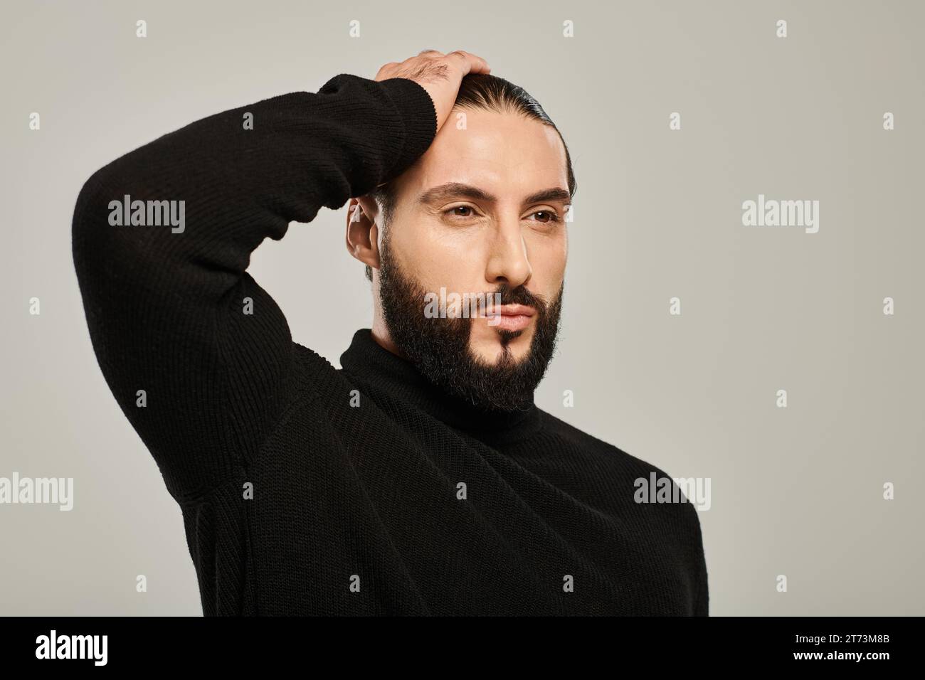 portrait of handsome arabic man with beard posing in black turtleneck ...