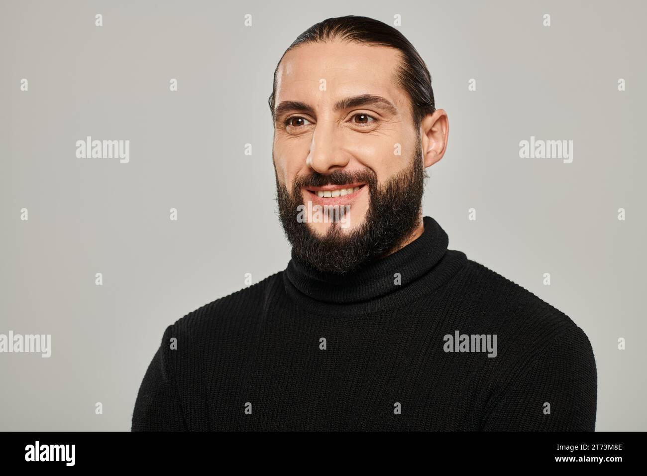 portrait of cheerful and handsome arabic man with beard posing in black ...