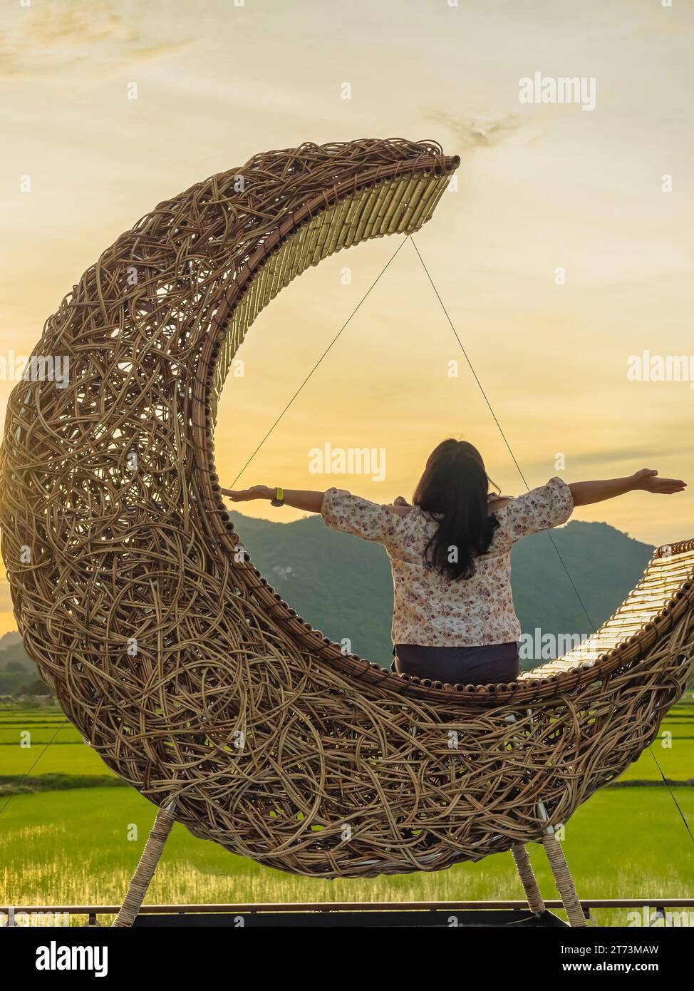 Woman sit on crescent moon chair made of rattan for relaxation on ...