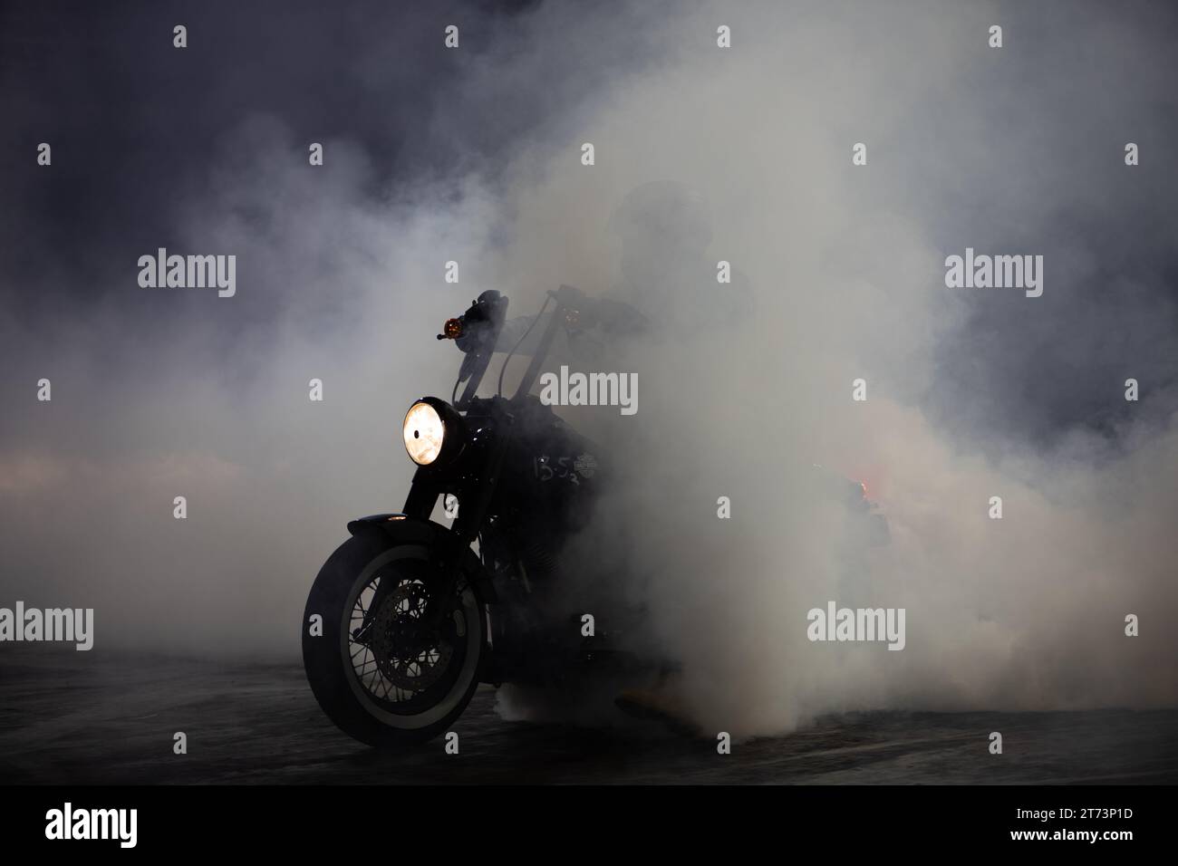 A close up of a motorcycle's rear wheel spinning rapidly, with smoke ...