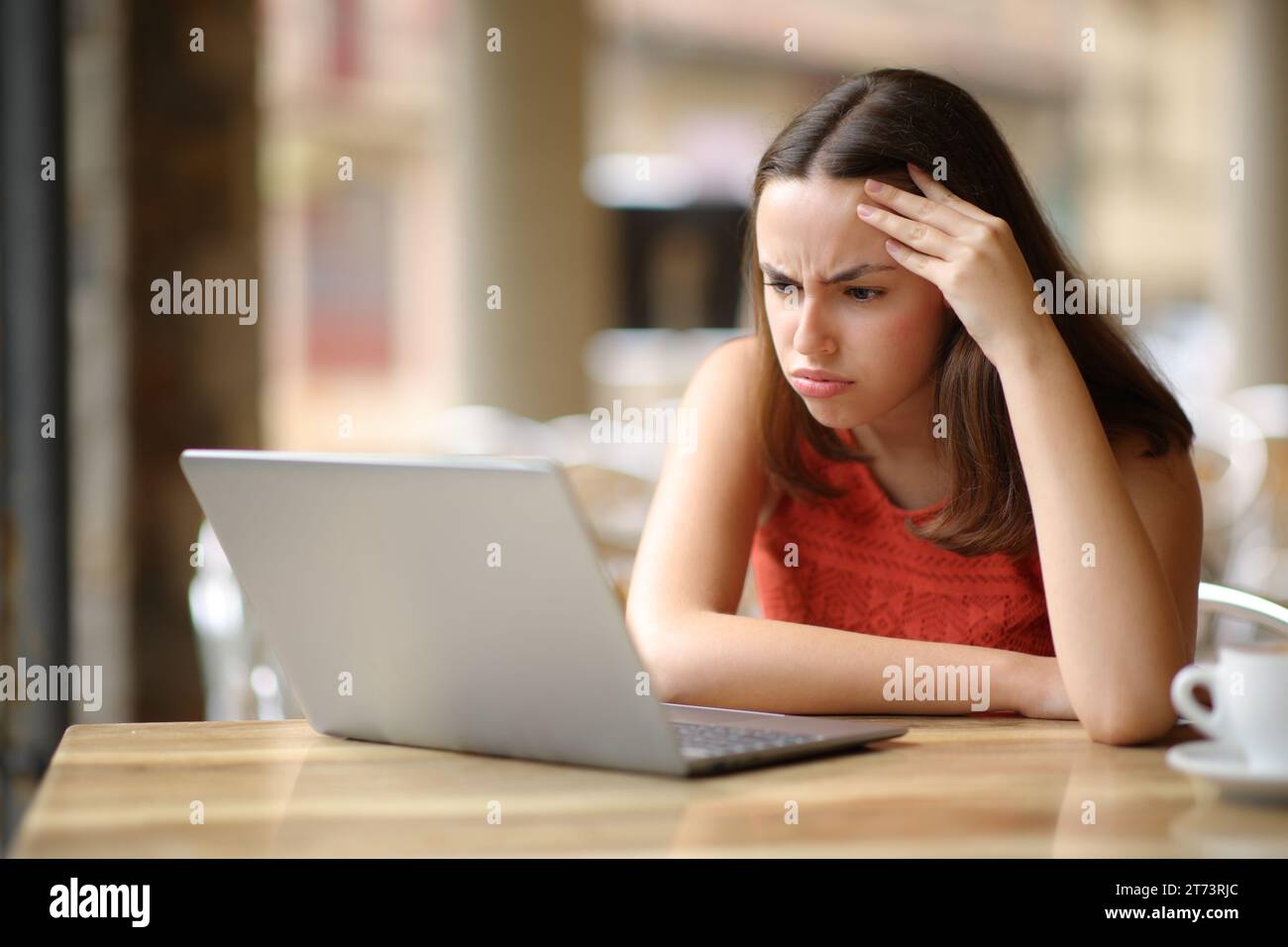 Frustrated woman checking laptop content in a bar terrace Stock Photo ...