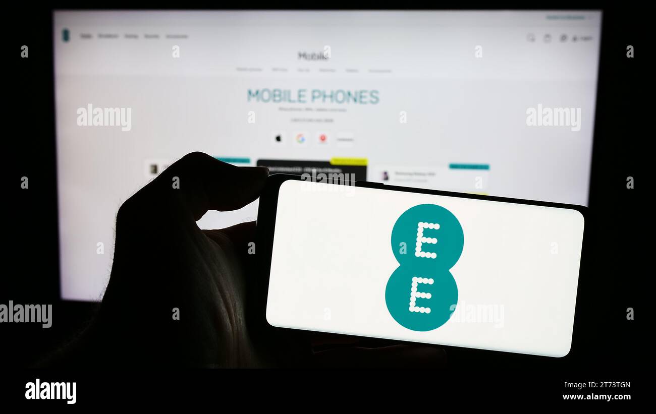 Person holding cellphone with logo of British telecommunications ...