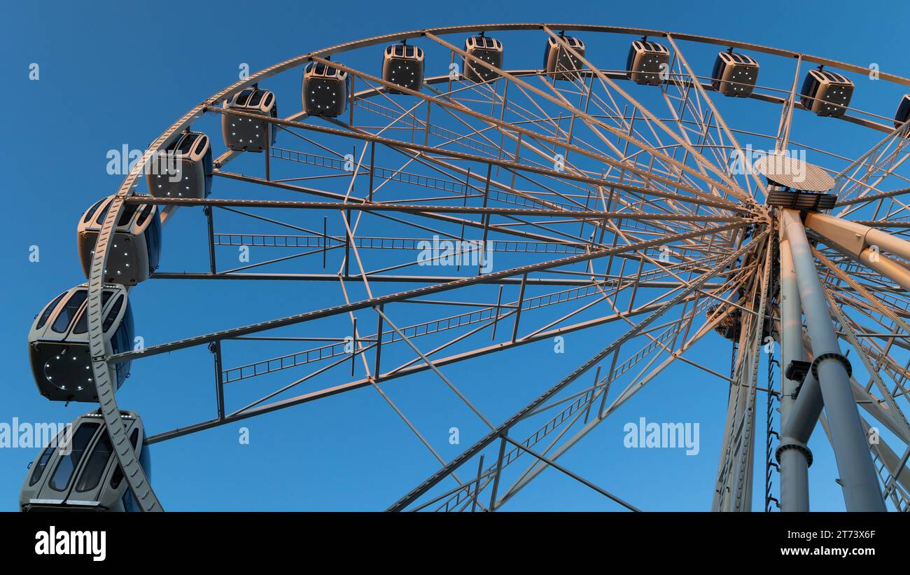 Ferris wheel in the background of the blue sky. Details of steel ...