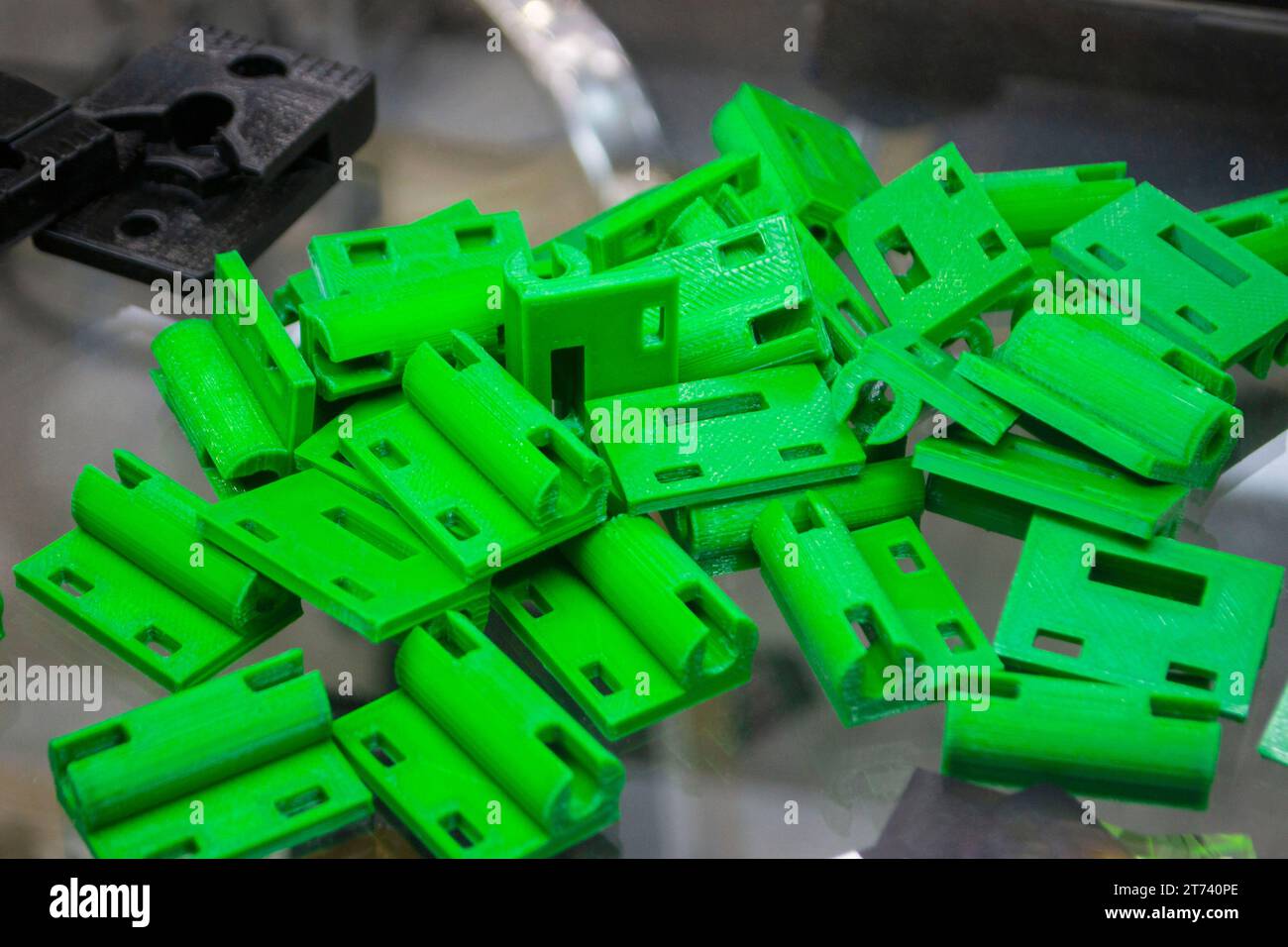 Many details printed on 3D printer from molten plastic green color ...