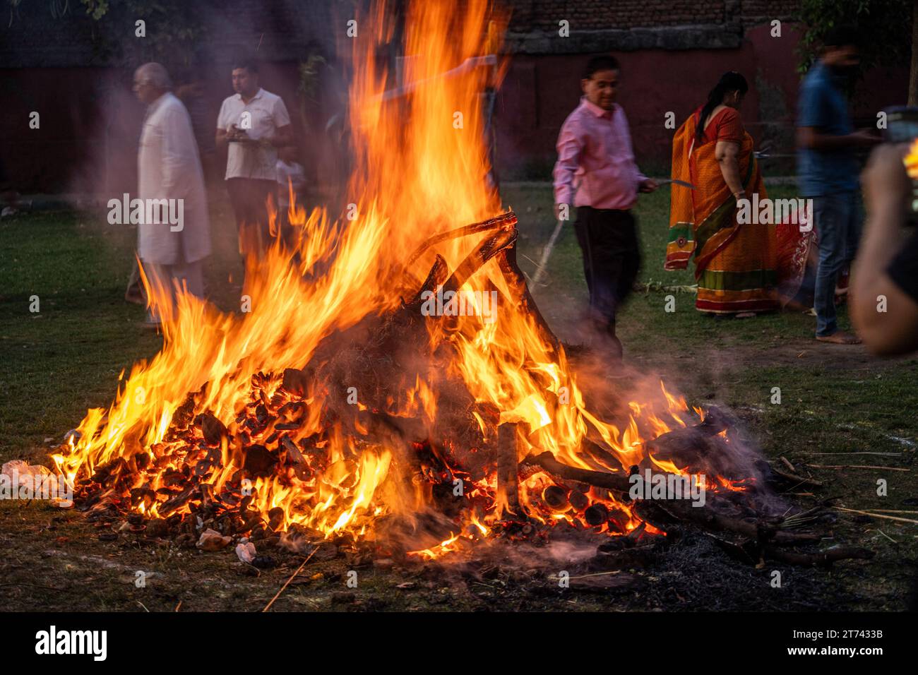people dancing around a huge bon fire on the hindu festival of holi ...