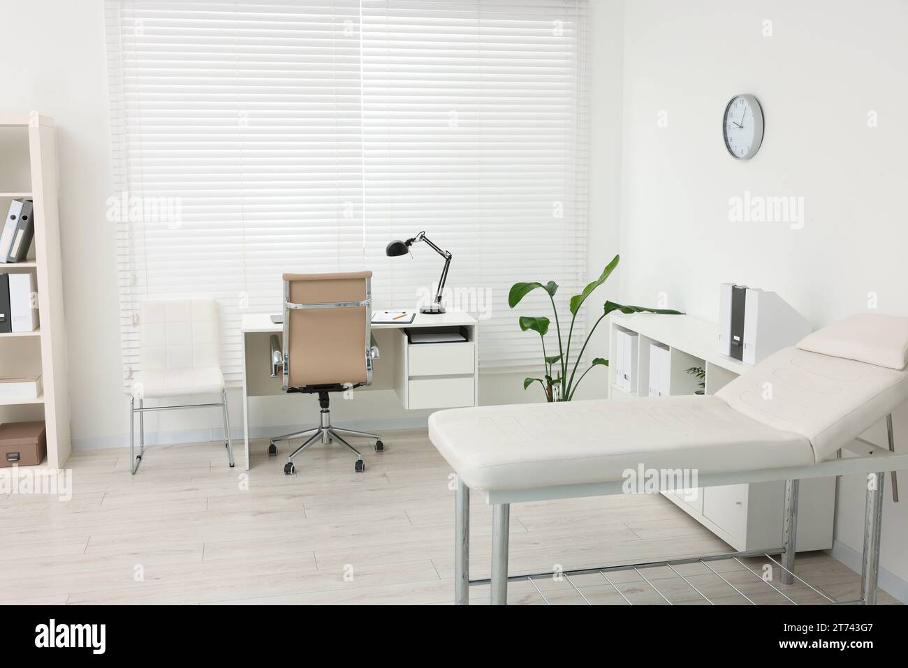 Modern medical office with doctor's workplace and examination table in ...