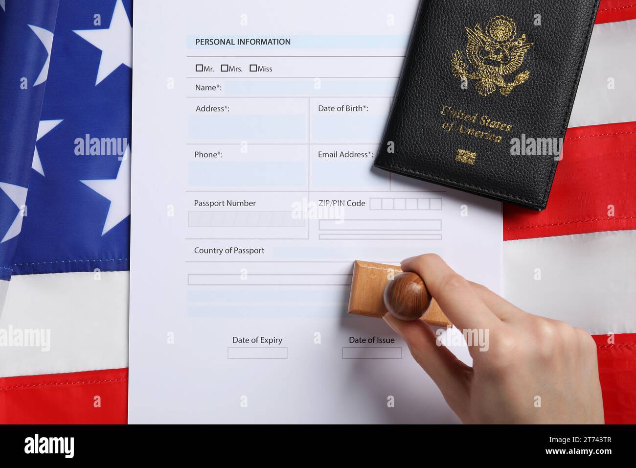Immigration to USA. Woman stamping visa application form on flag, top ...