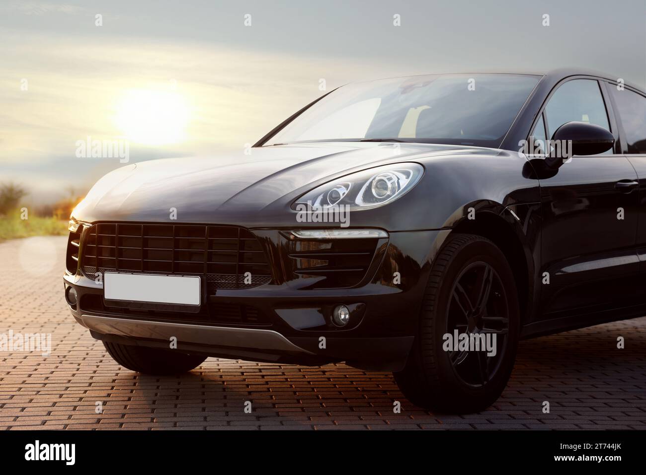 Modern black car parked on stone pavement outdoors Stock Photo - Alamy