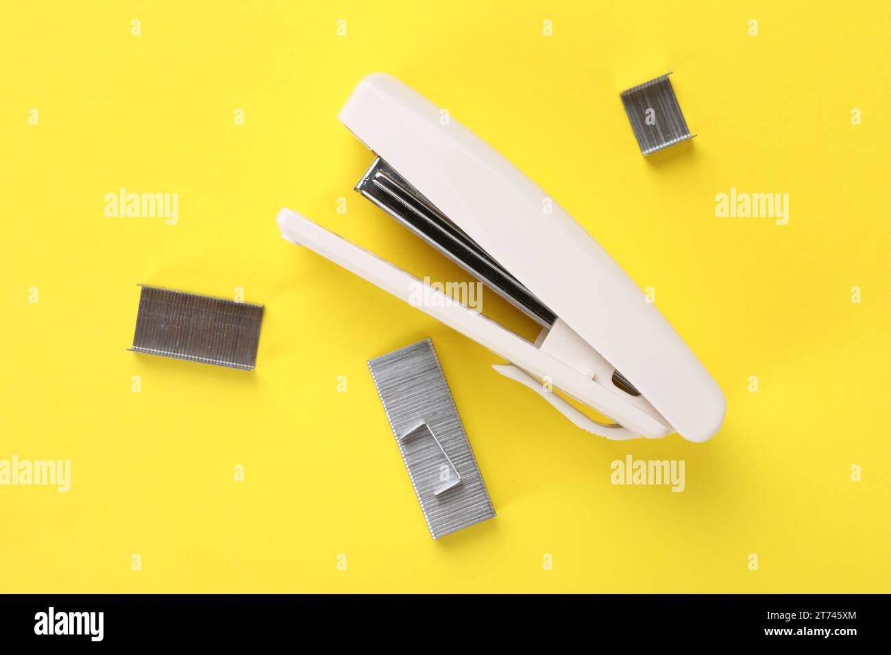 White stapler with staples on yellow background, flat lay Stock Photo ...