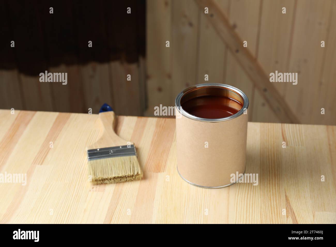 Can with wood stain and brush on wooden surface Stock Photo - Alamy