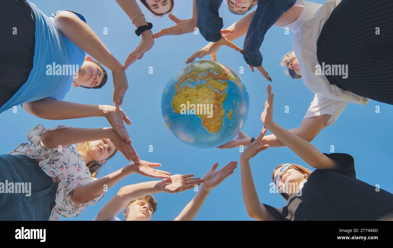 Young boys surround the globe of the world with their palms. The ...