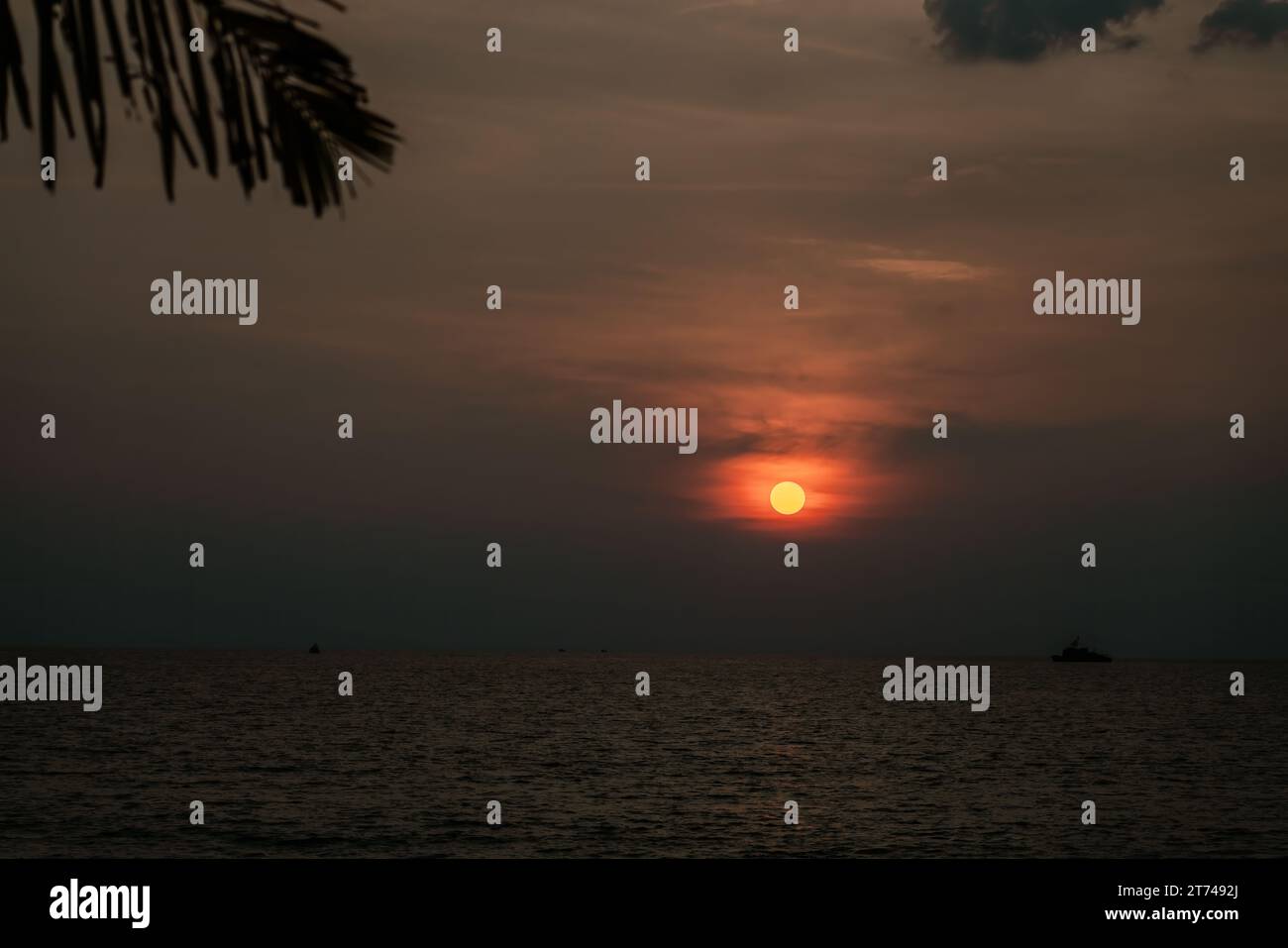 Scenic golden red sunset, Sun partly behind clouds, tropical sky ...