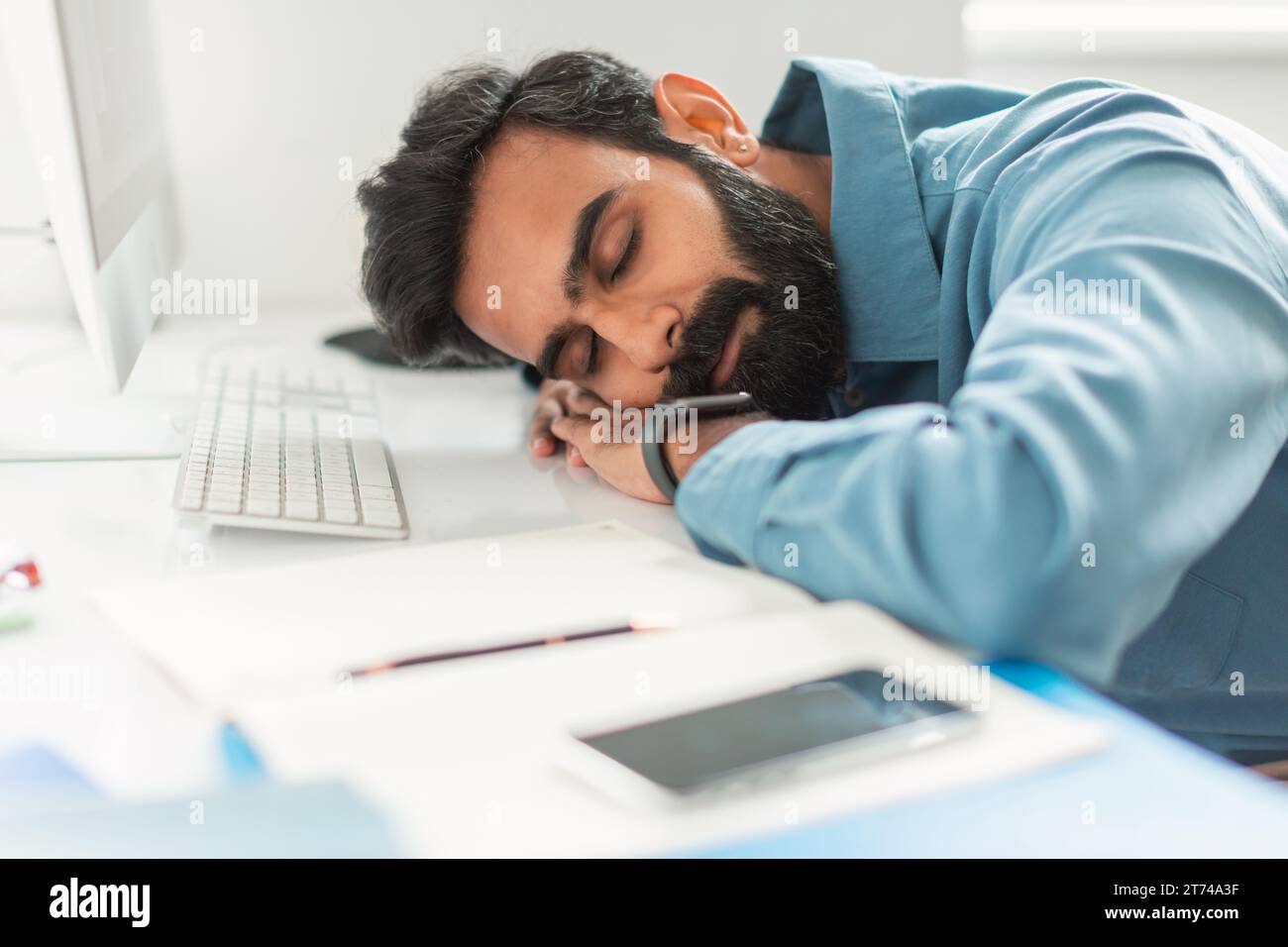 Exhausted indian man asleep at his desk Stock Photo - Alamy