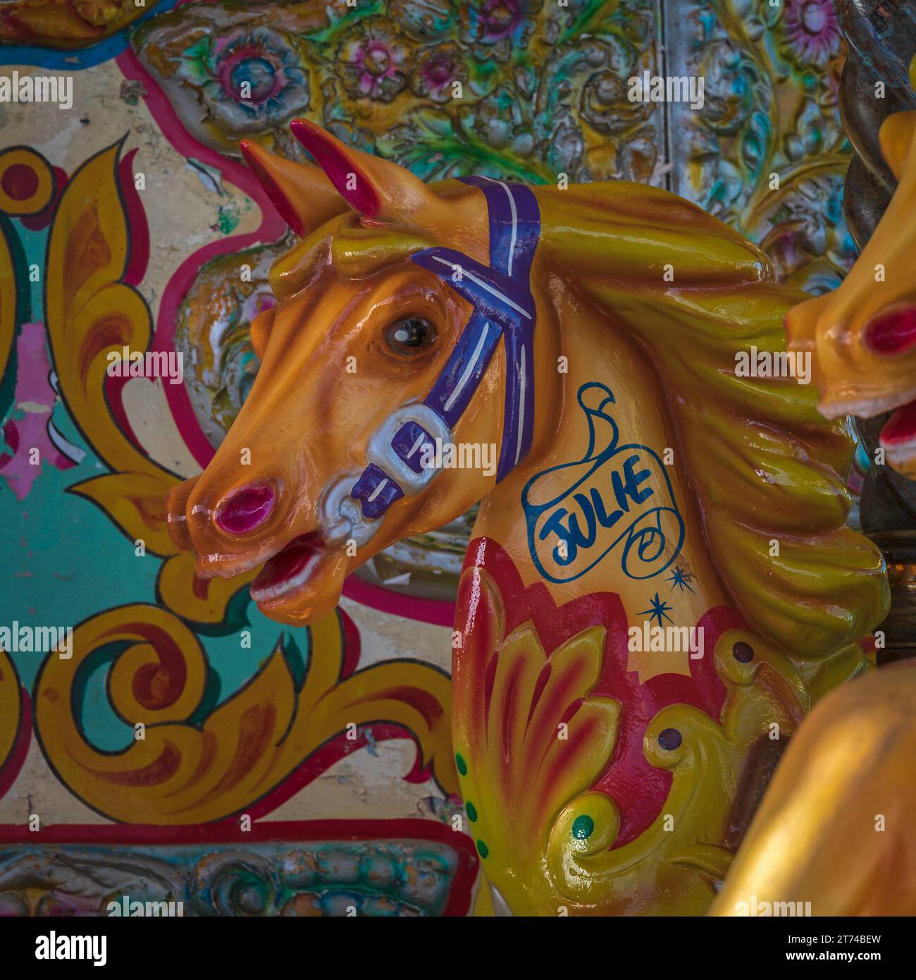 Gaudily painted horses on the Carousel in the fairground on the Palace ...