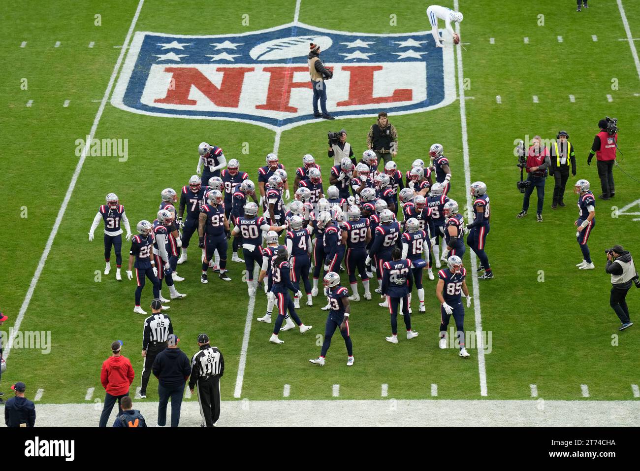 The New England Patriots huddle on the field before an NFL football ...