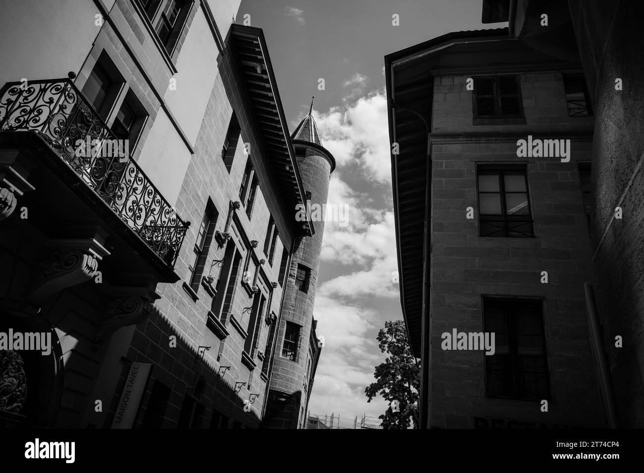 A tall modern building with a round spire on top stands on a ...