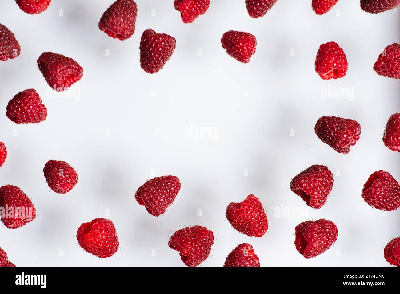 Fresh ripe falling raspberries isolated on white. Abstract fruit ...