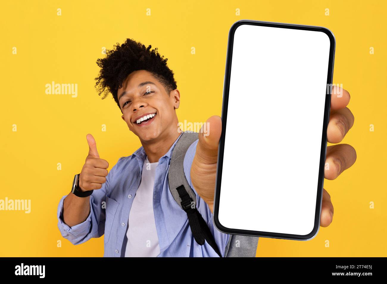 Cheerful black guy student showing phone screen and gesturing thumb up Stock Photo - Alamy