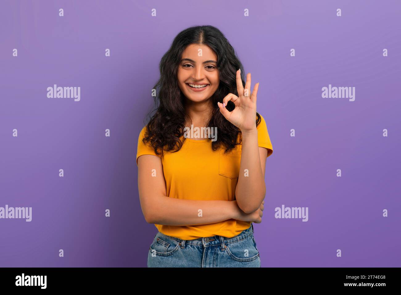 Positive young hindu lady showing okay gesture on purple Stock Photo ...