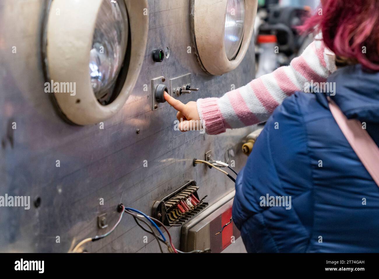 A child's hand pressing a button in a workshop Stock Photo - Alamy