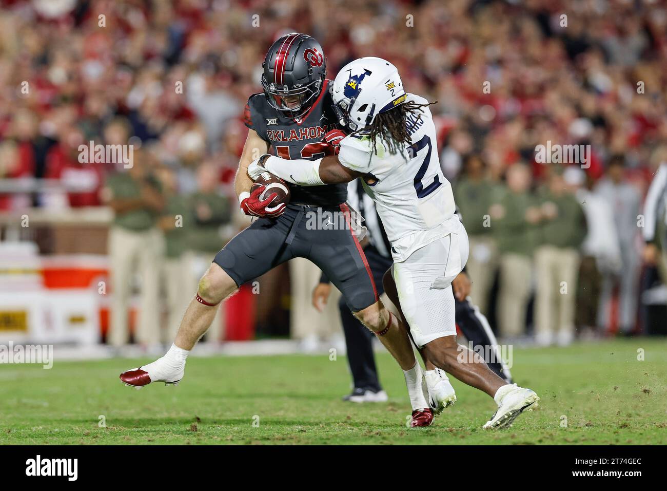 Oklahoma wide receiver Drake Stoops (12) is tackled by West Virginia ...