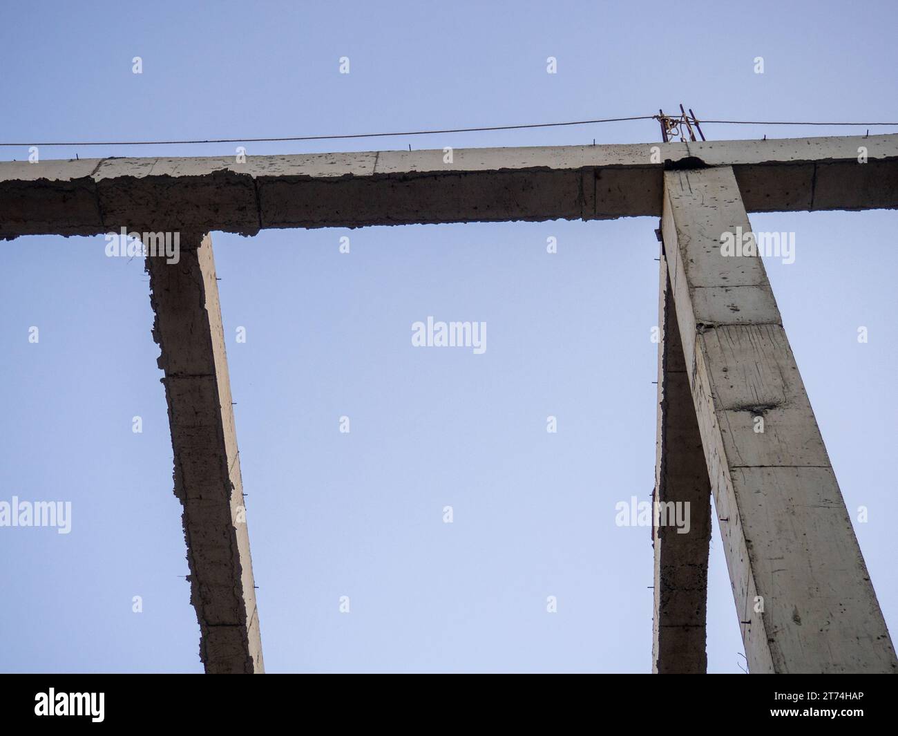 Structure made of concrete piles. Frame of a house under construction. Stone beams. Remains of ...