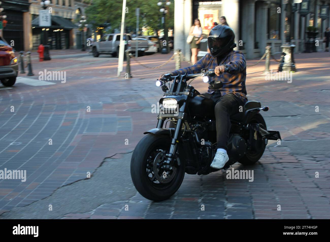 A man wearing an all-black leather jacket is seen riding a motorcycle ...