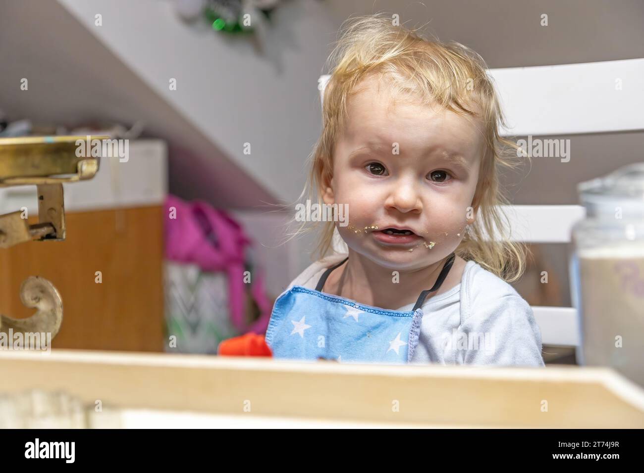 Portrait of a cute little boy with dough crumbs on his face closeup ...