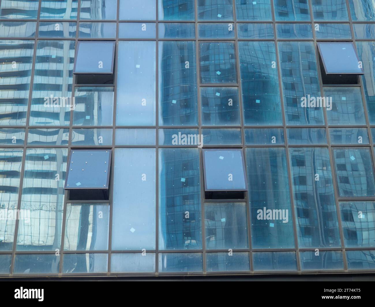 Glass facade of a house under construction with open windows. Unwashed ...