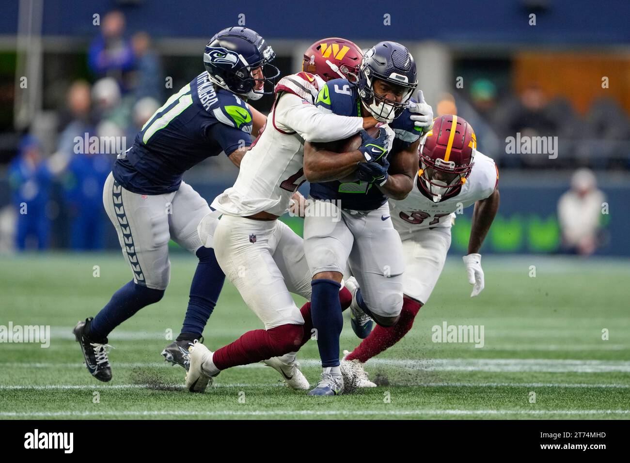 Seattle Seahawks running back Kenneth Walker III, center, is tackled by ...