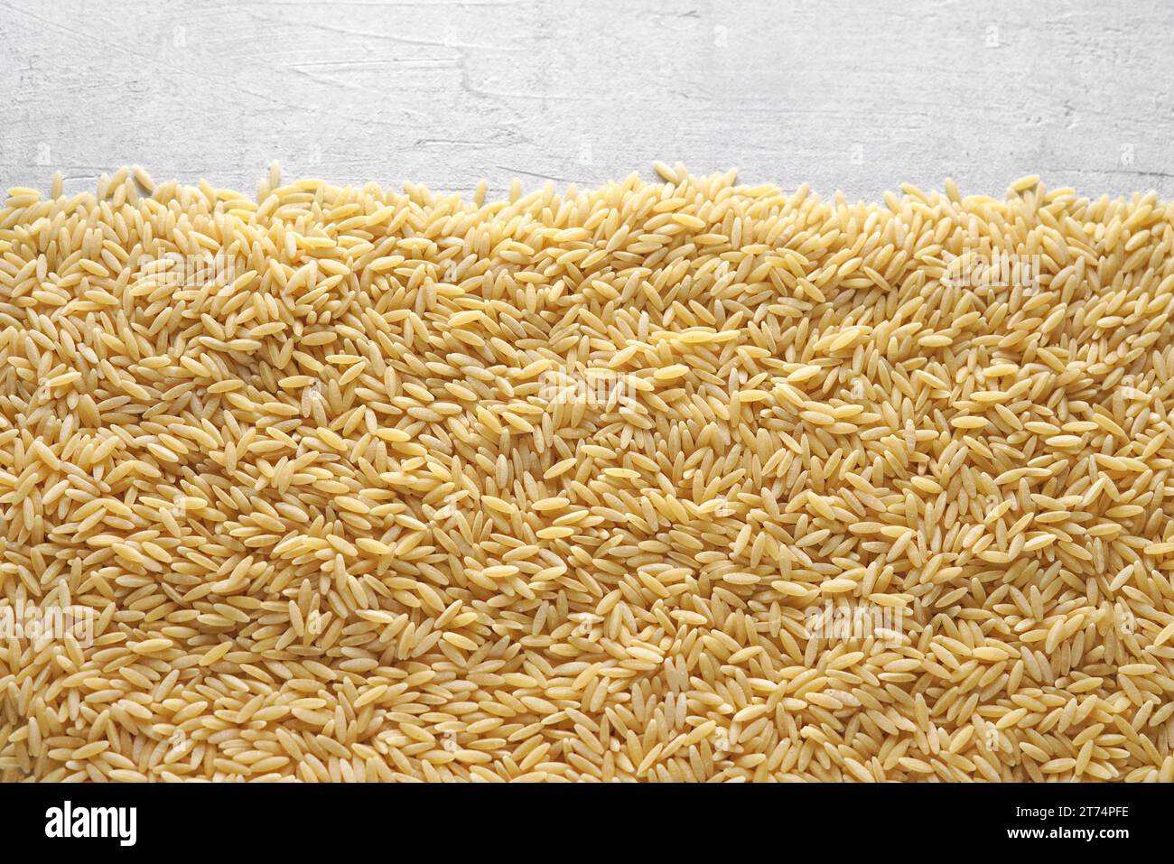 Italian pasta orzo on a light background, top view. Close-up of hard ...