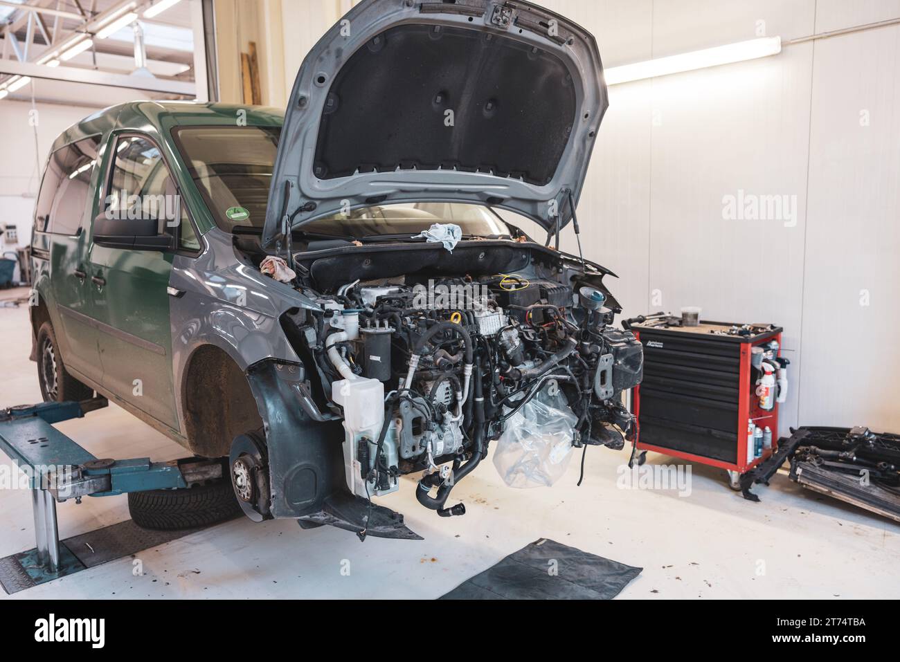A car without the front and without the hood is standing in a garage ...