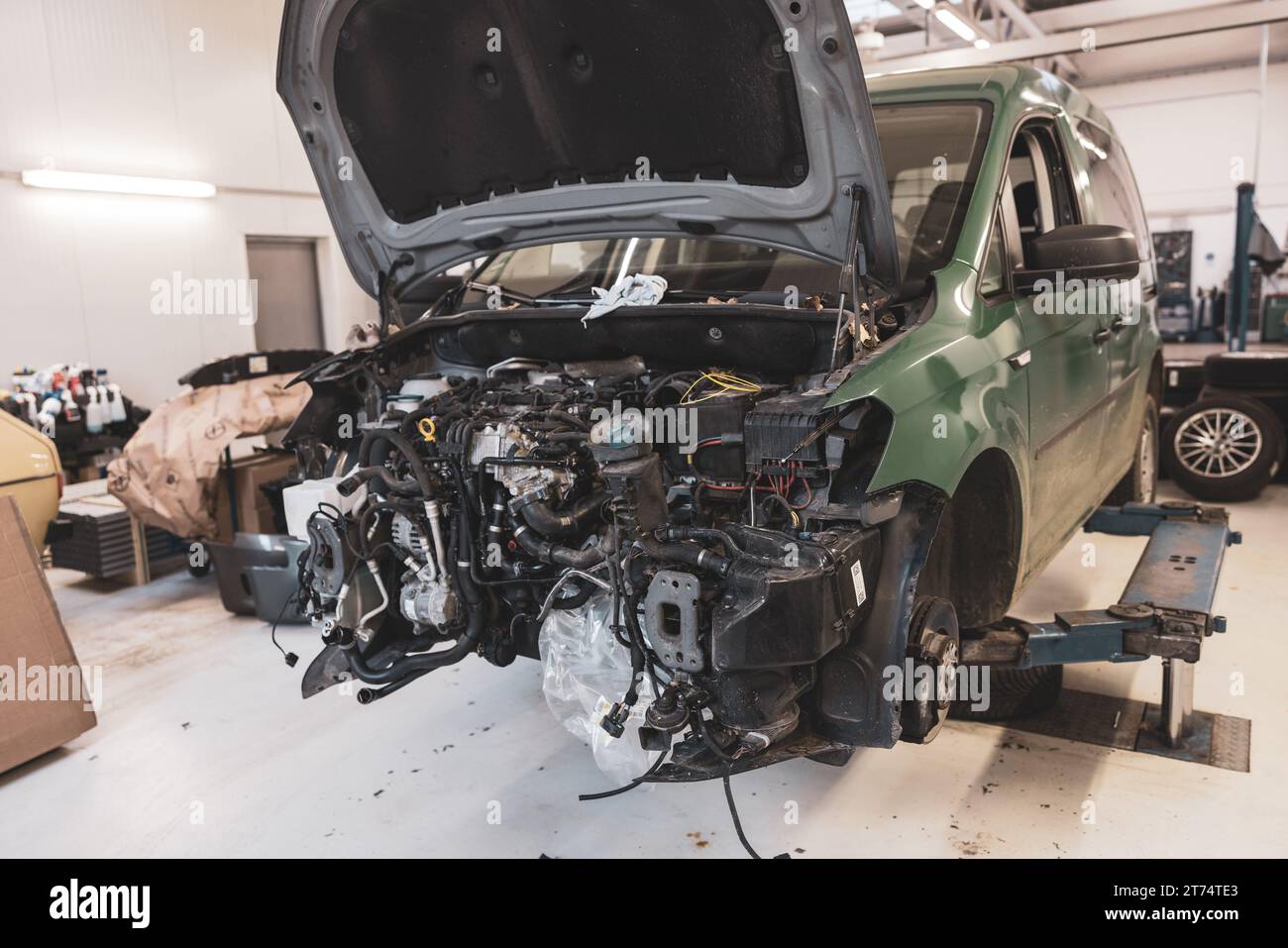 A car without the front and without the hood is standing in a garage ...