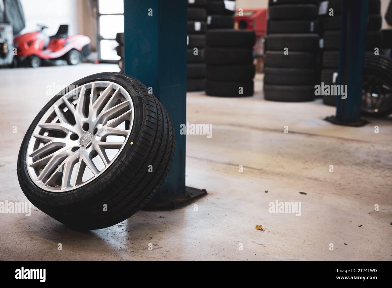 a complete wheel leans against a pillar in a car repair shop Stock ...