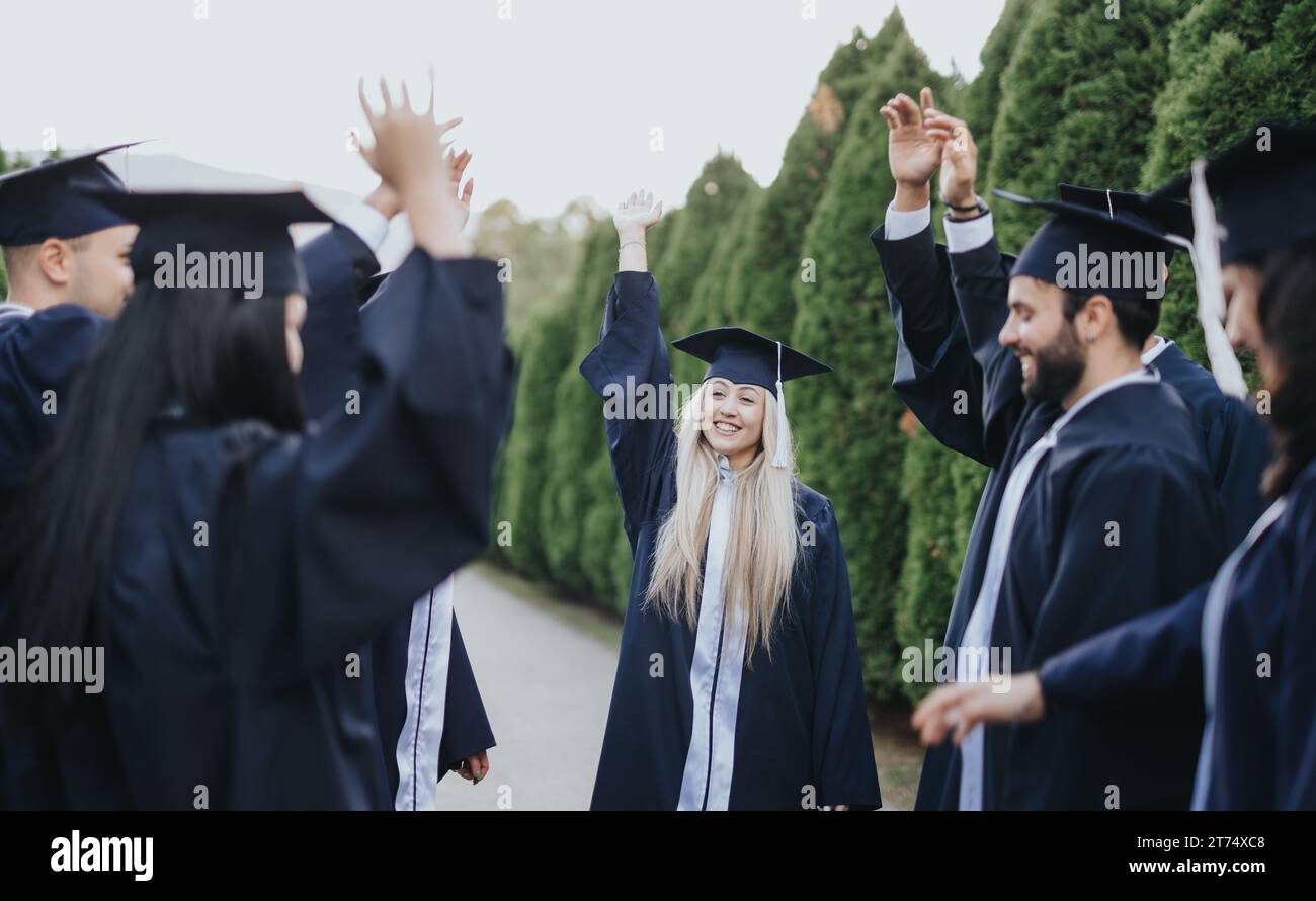 Diverse university students celebrate their graduation in a park ...