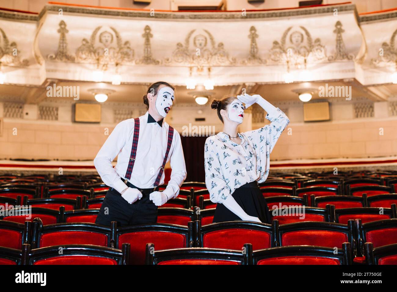 Male mime looking female mime looking up auditorium Stock Photo - Alamy