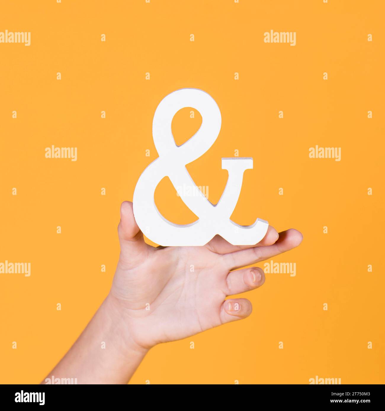 Woman s hand holding sign yellow background Stock Photo - Alamy