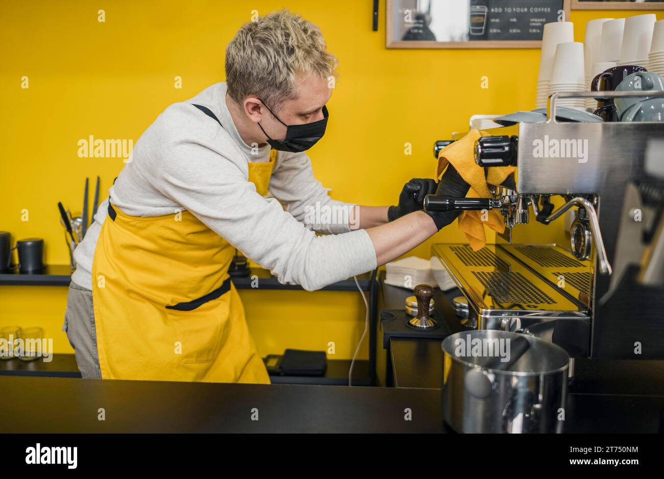 Side view male barista with medical mask cleaning coffee machine Stock ...